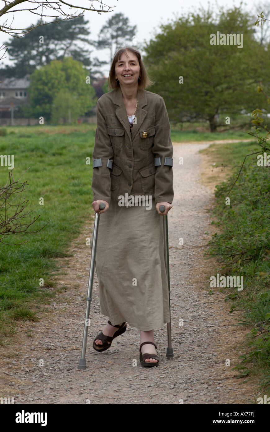 Lady walking with crutches Stock Photo - Alamy