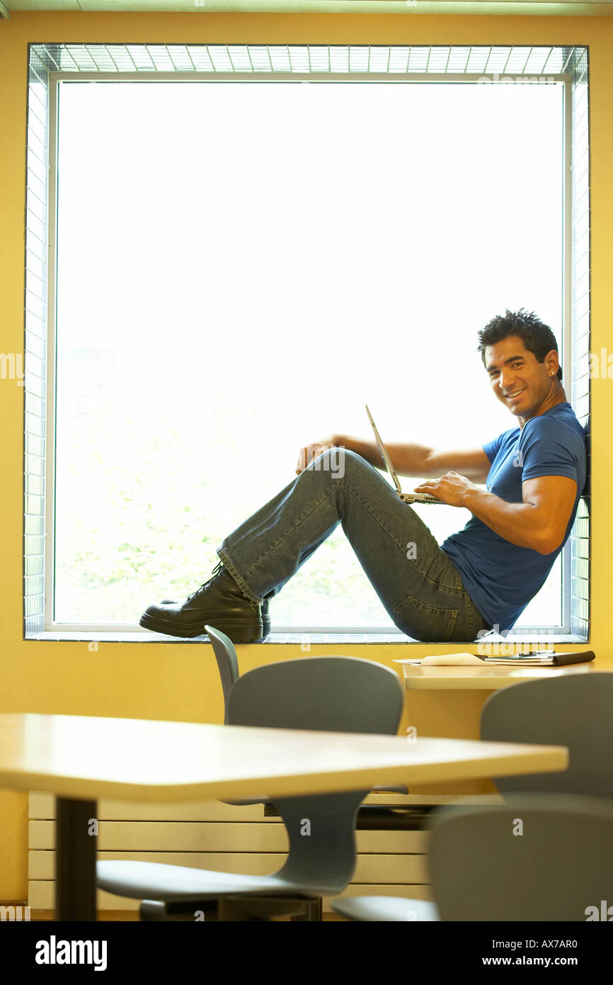Man sitting on window ledge hi-res stock photography and images - Alamy