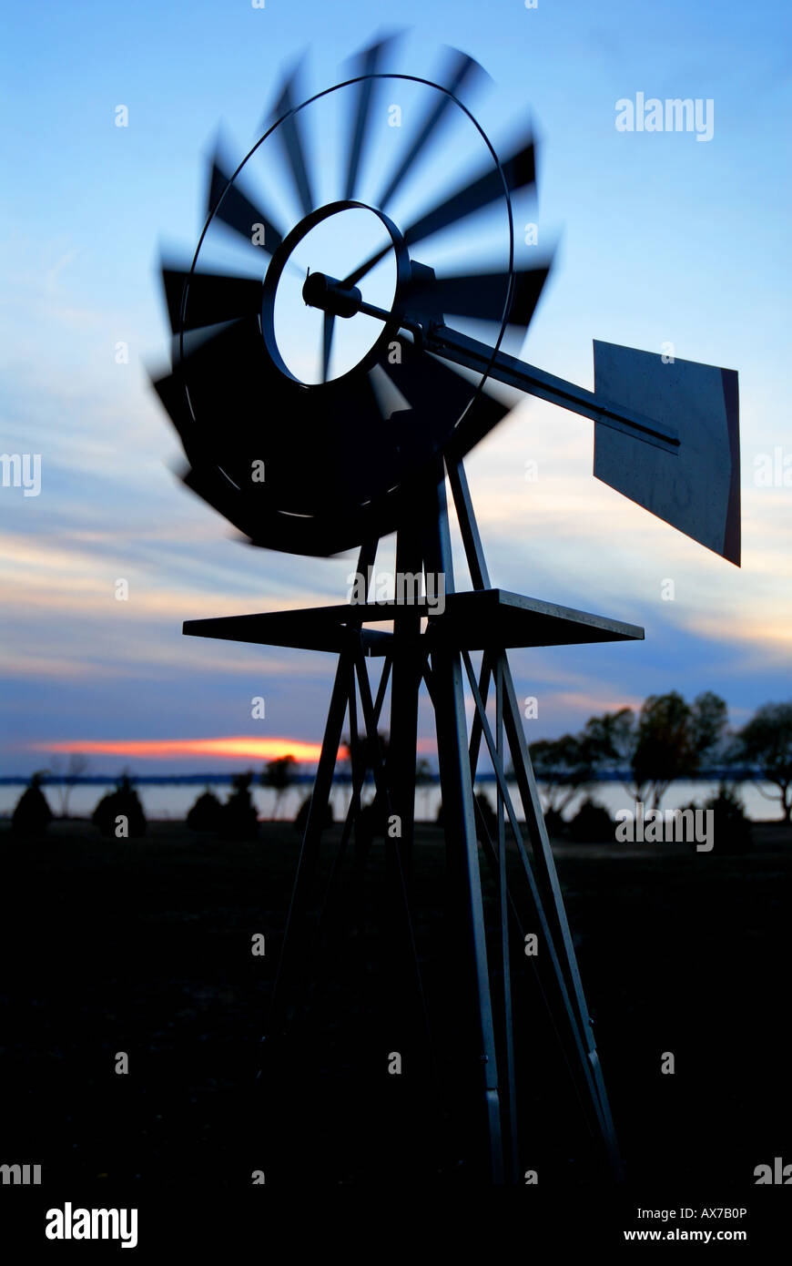 Windmill with lake at sunset Stock Photo - Alamy