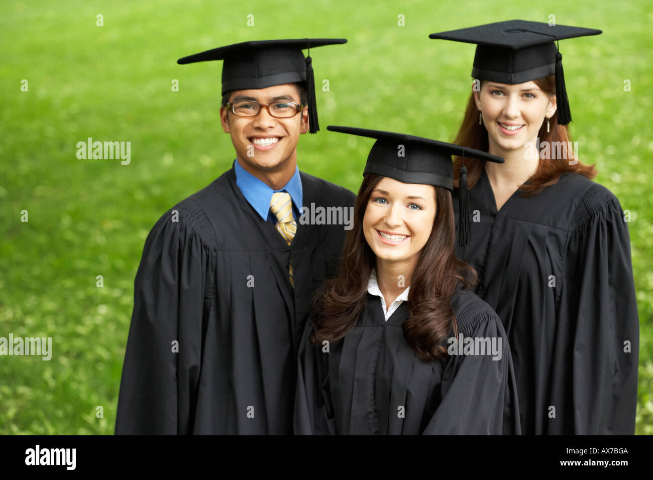 Two female graduates and a male graduate smiling Stock Photo - Alamy