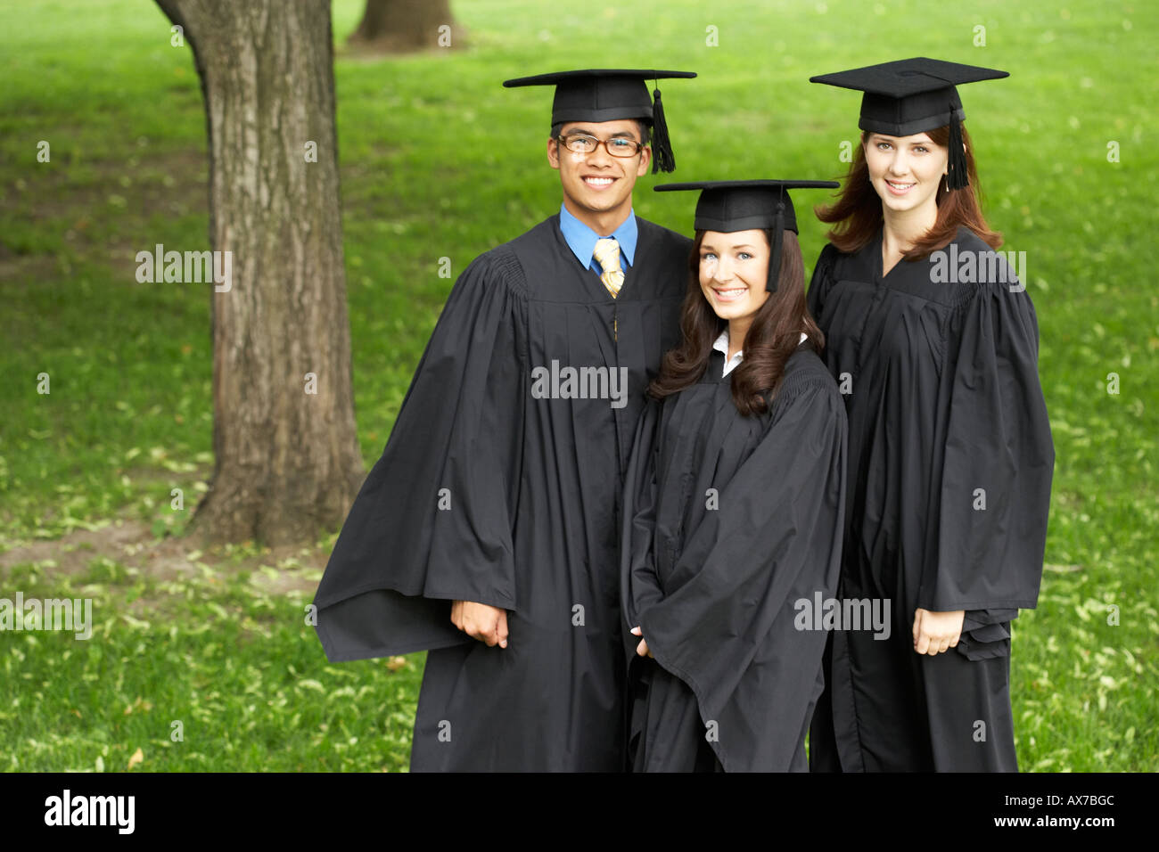 Two female graduates and a male graduate smiling Stock Photo - Alamy