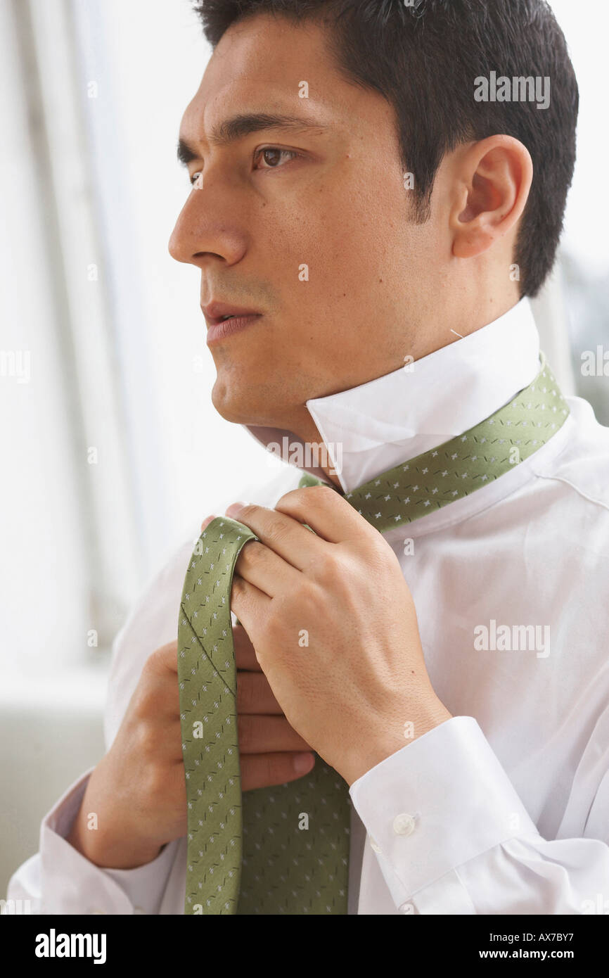 Side profile of a businessman tying his tie Stock Photo - Alamy