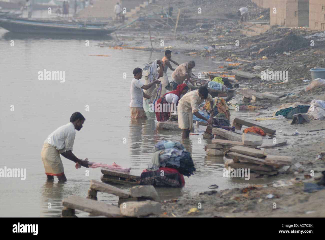 Laundry workers washing clothes on the banks of the holy River Ganges ...