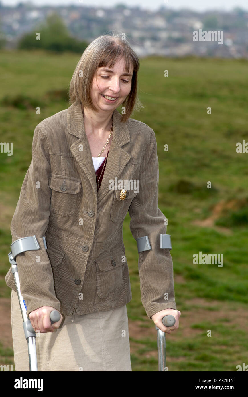 Lady walking with crutches Stock Photo - Alamy
