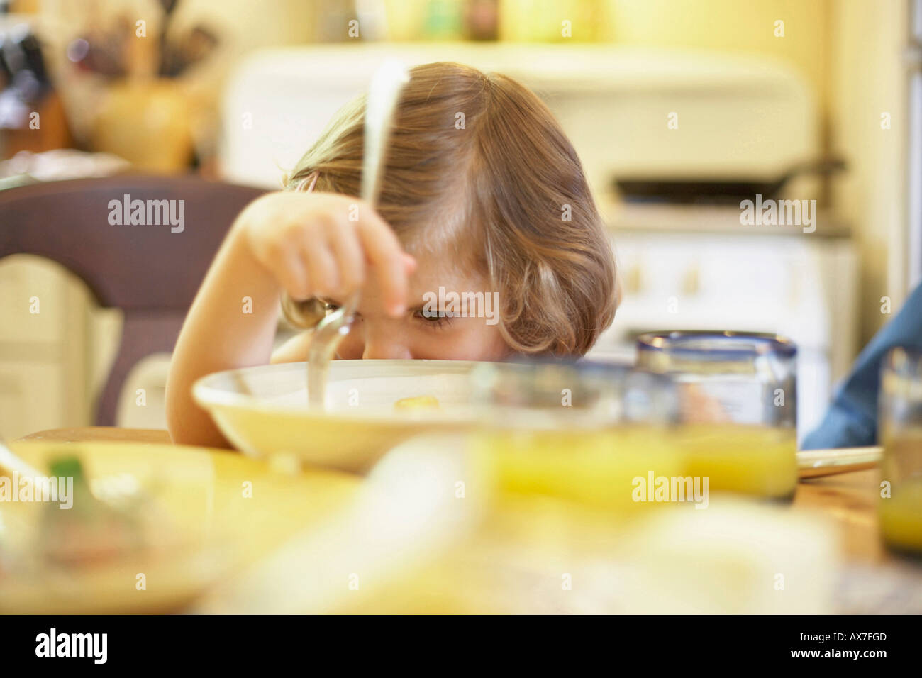 Girl sitting at a dining table Stock Photo - Alamy