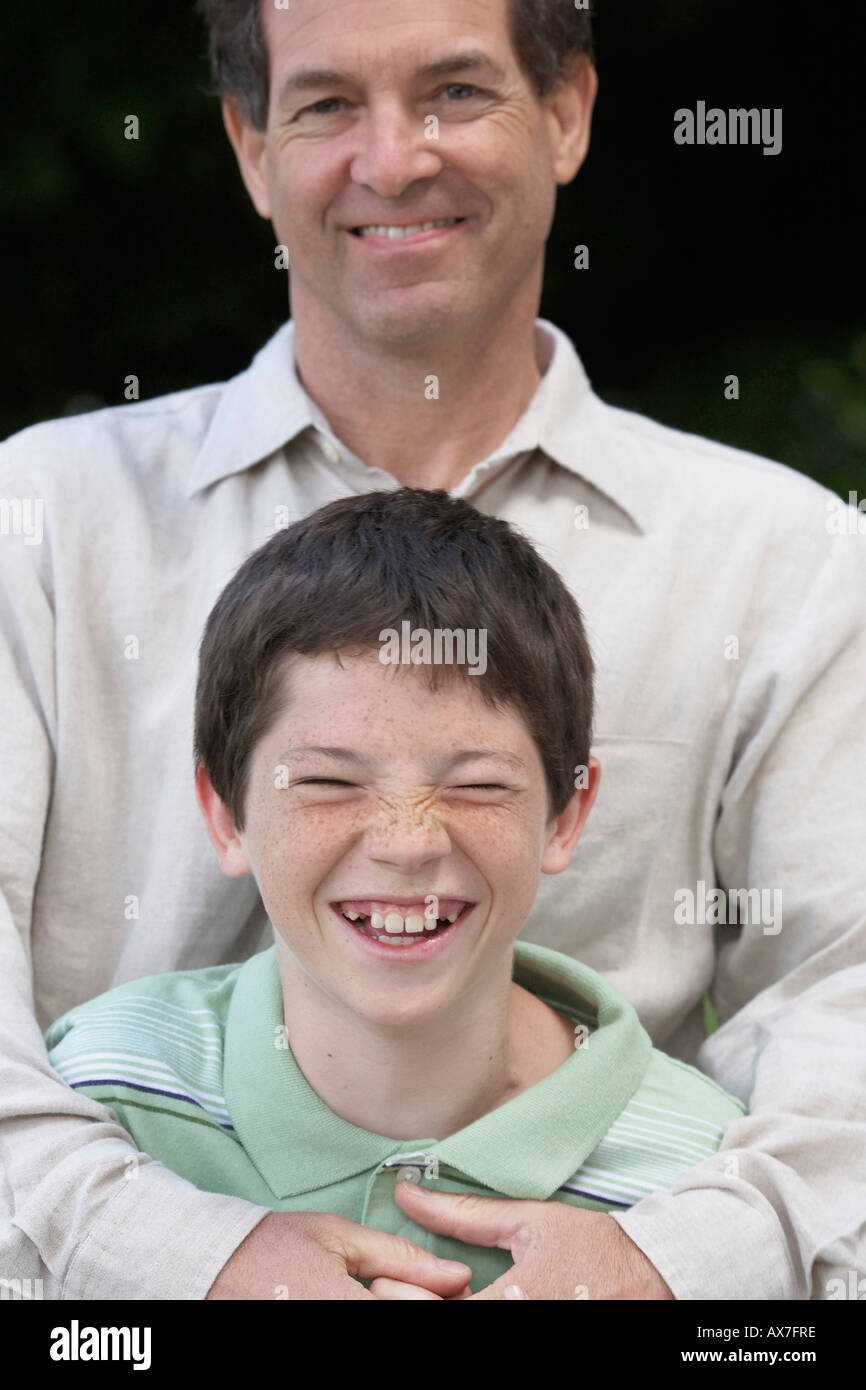 Portrait of a mid adult man smiling with his son Stock Photo - Alamy