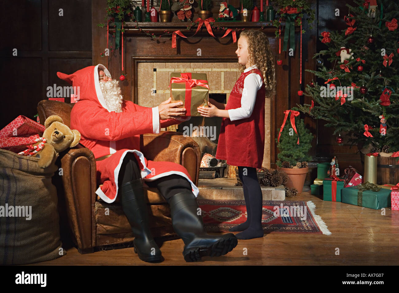 Santa claus giving girl a gift Stock Photo - Alamy