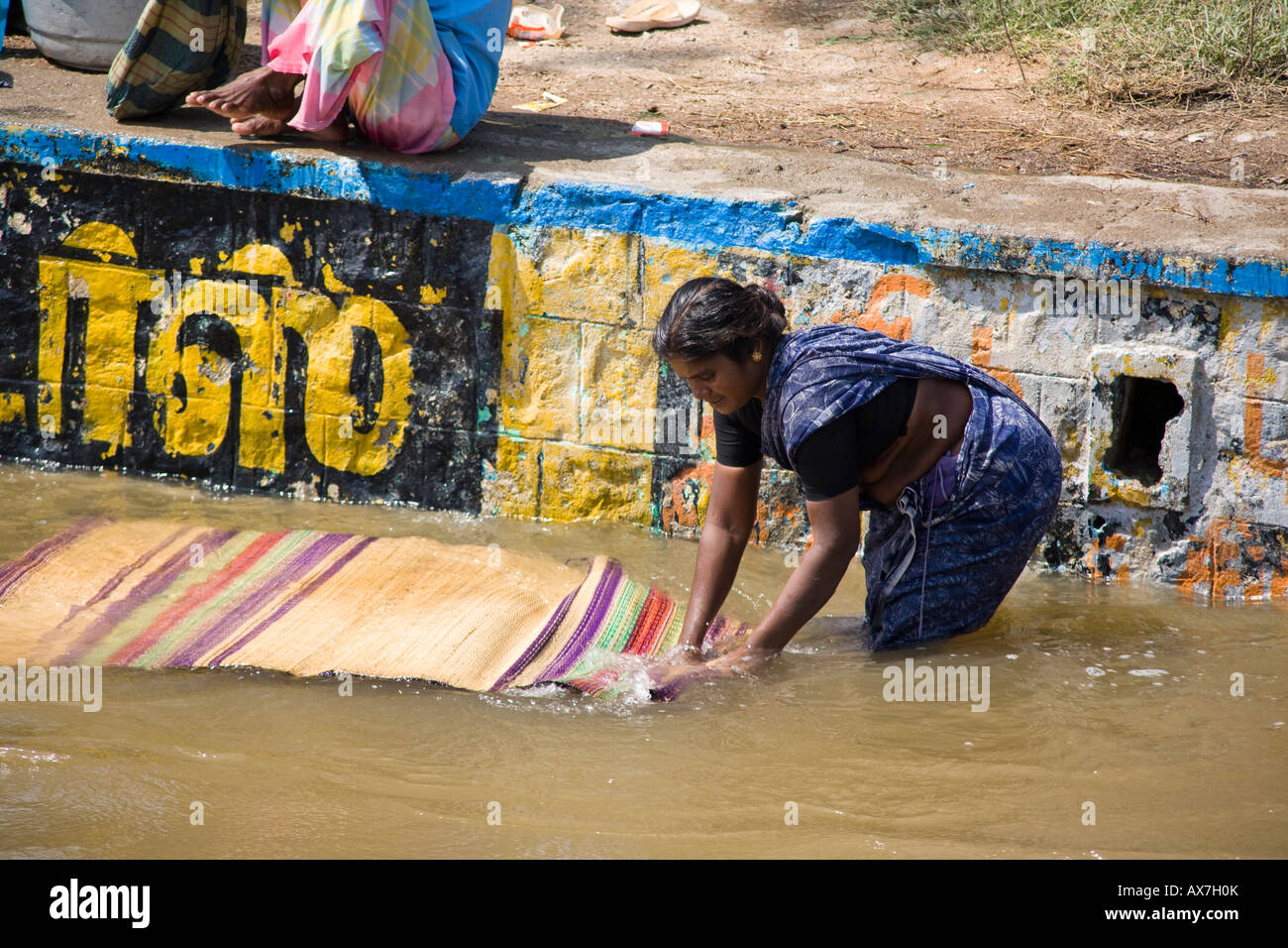 Woman washing a hessian carpet in a river, Tamil Nadu, India Stock ...