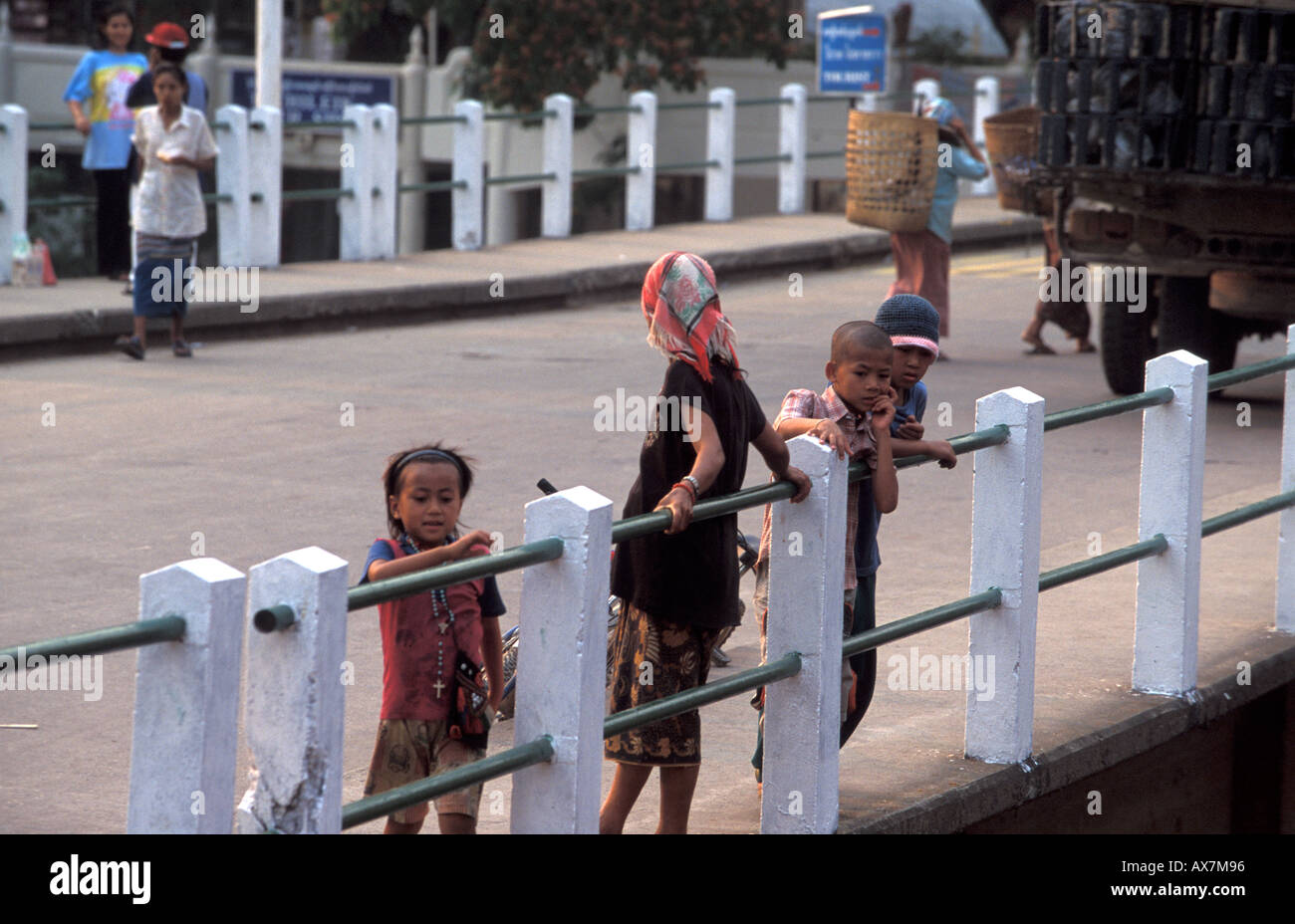 Children standing together on a bridge watching below Stock Photo - Alamy