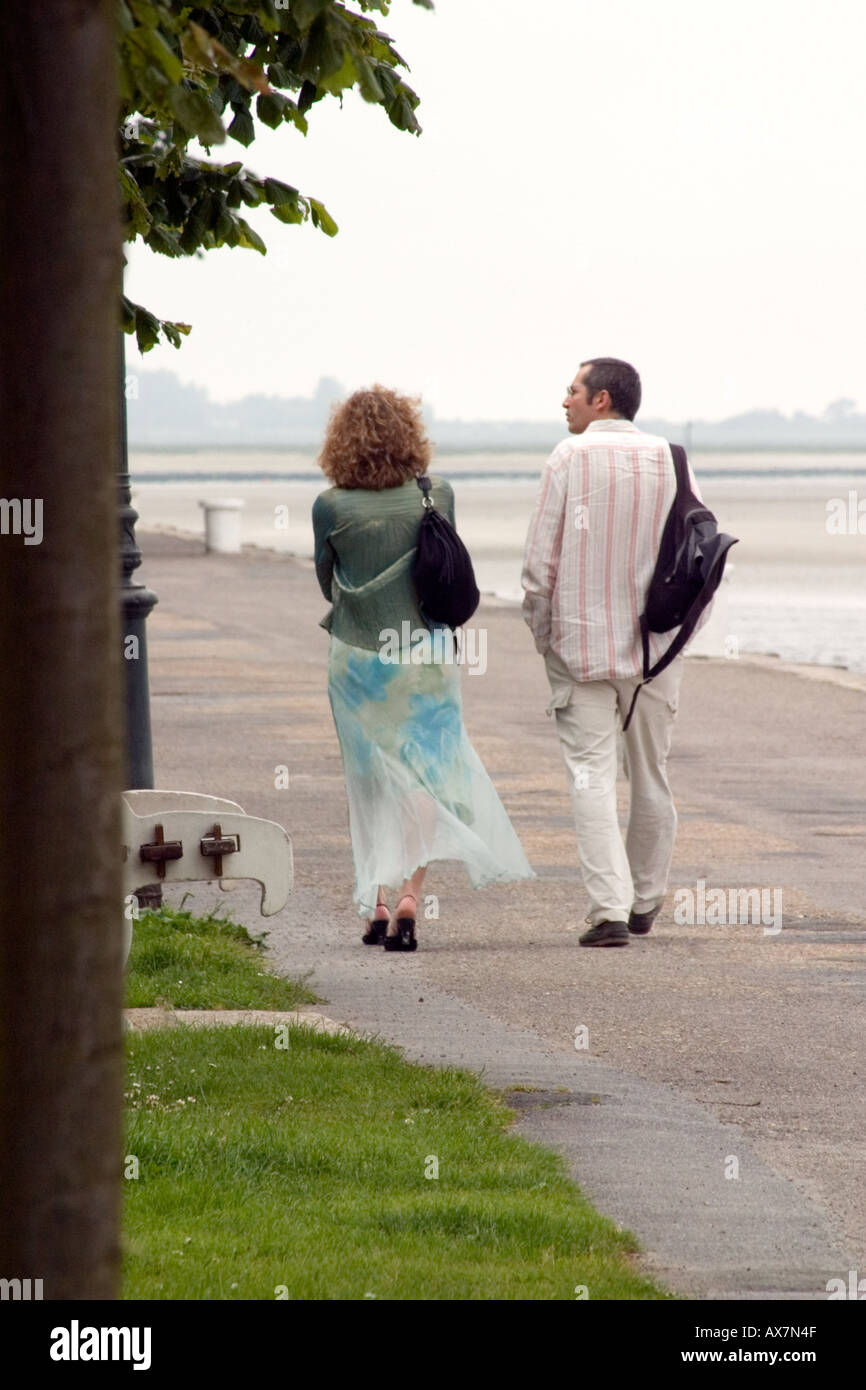 Elegant young couple taking an afternoon stroll along the promenade at ...