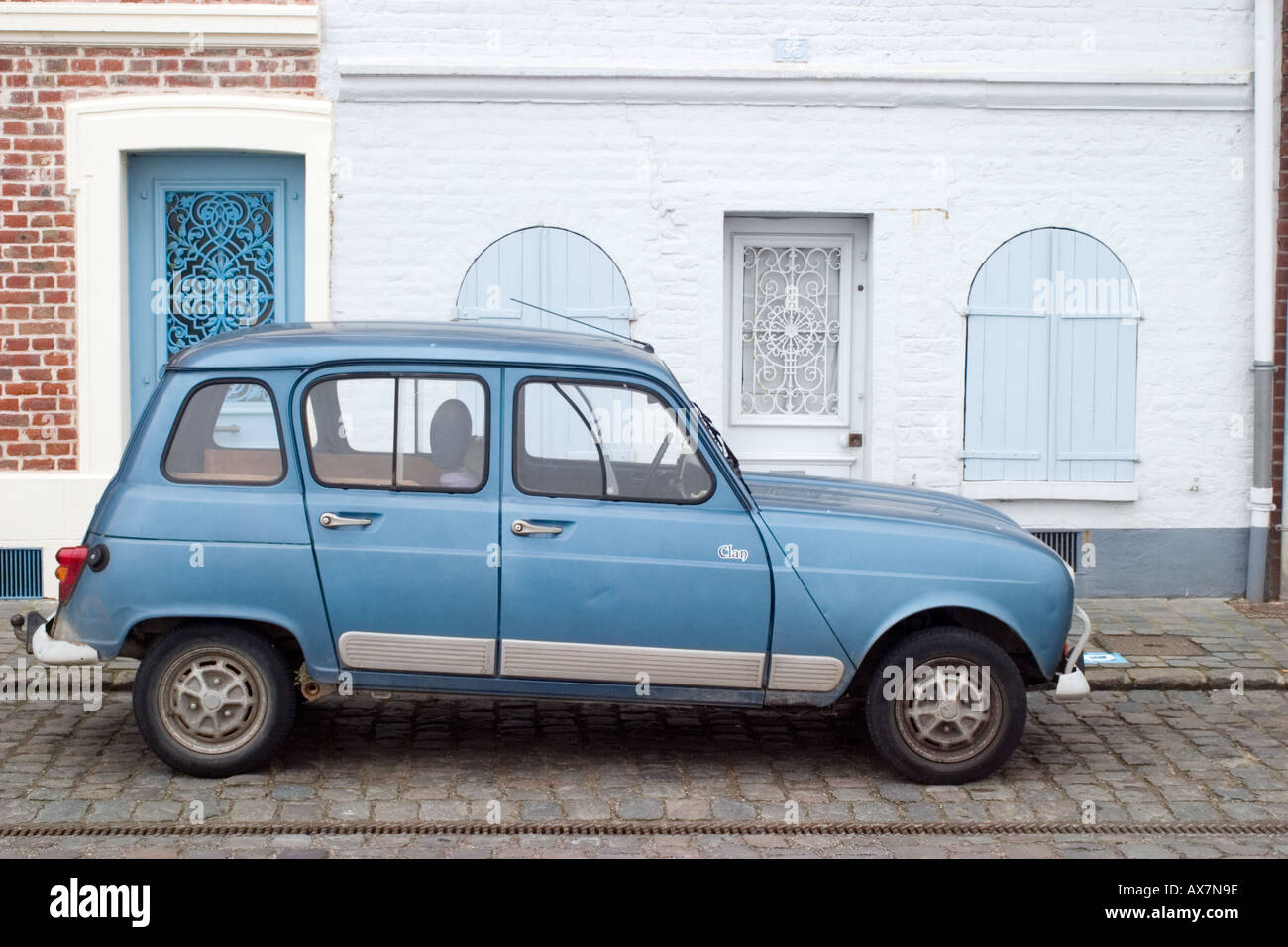 Blue vintage Renault car outside blue and white shuttered house in ...