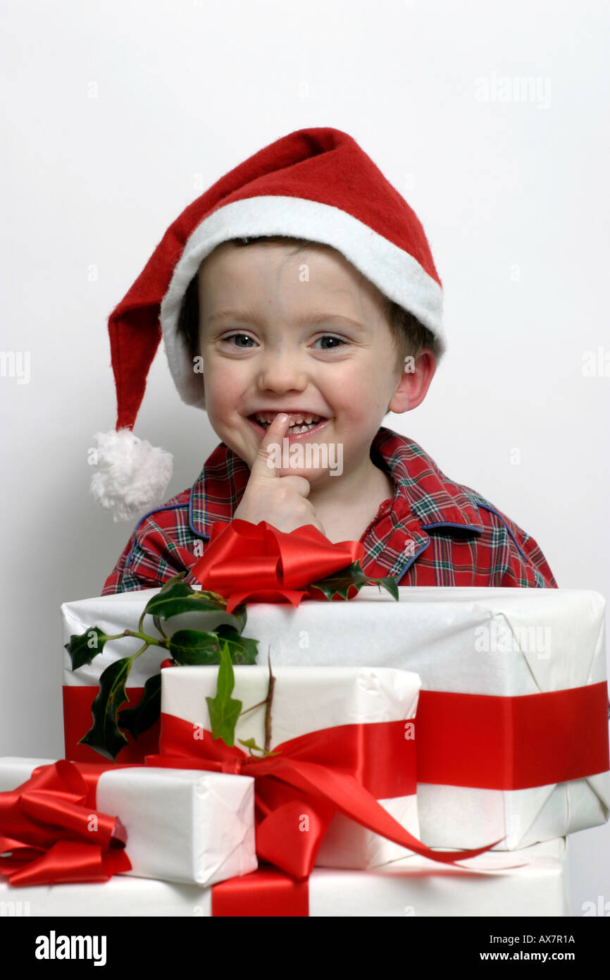 A little boy in his Christmas hat with lots of presents Stock Photo - Alamy