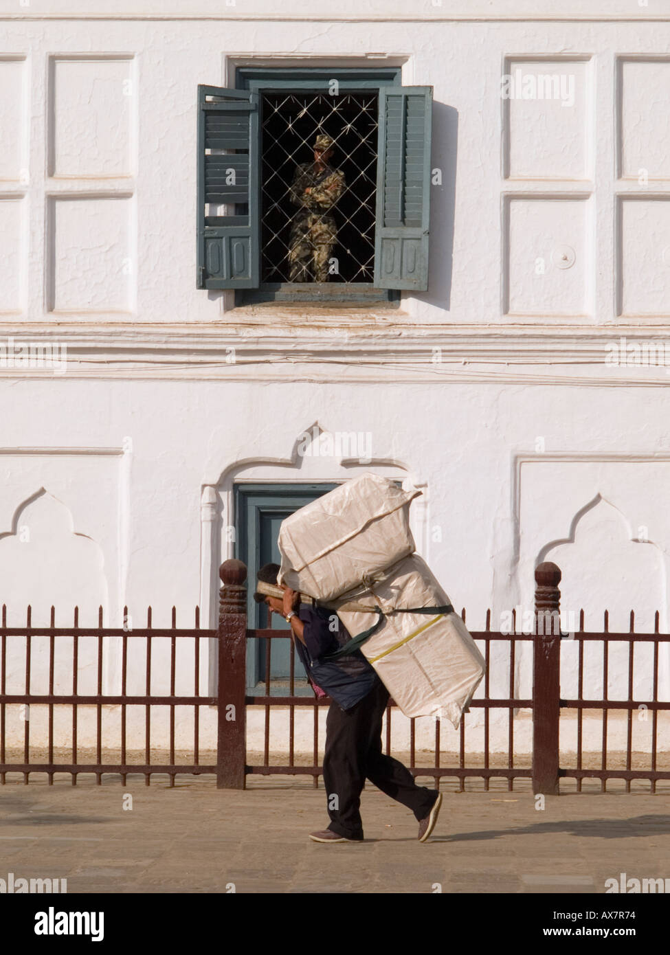 PORTER CARRYING LOAD SHERPA STYLE past part of Old Palace complex in ...