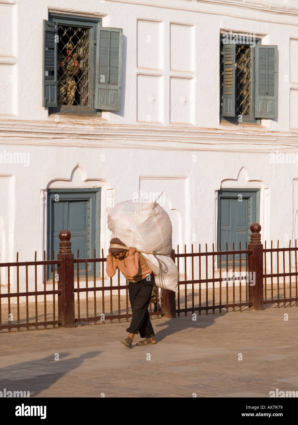 PORTER CARRYING LOAD SHERPA STYLE past part of Old Palace complex ...