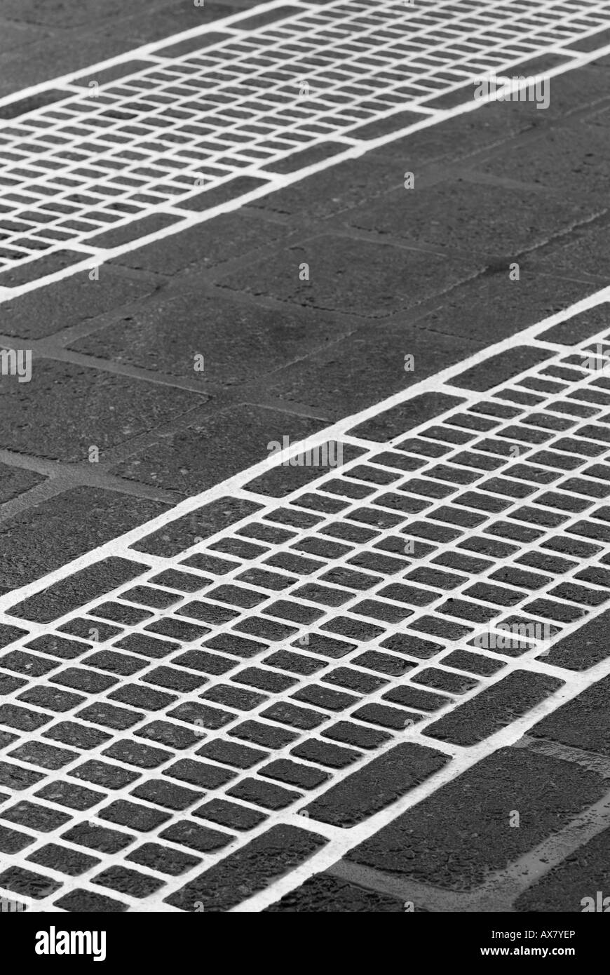 The graphic lines of a pedestrian sidewalk crossing on the surface of a ...