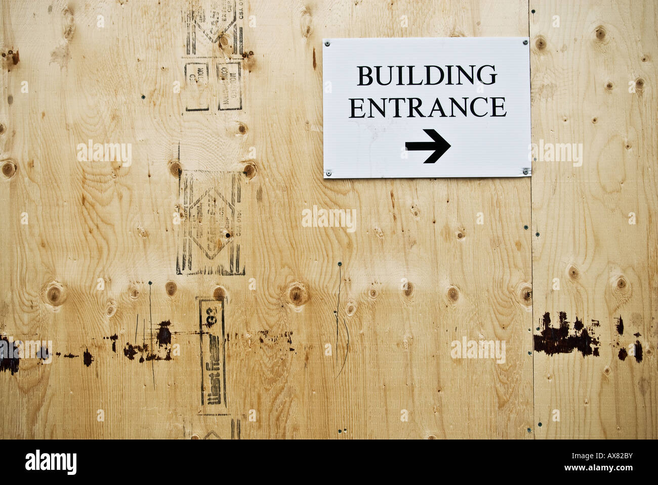 A sign attached to a wooden board denoting the entrance to the building ...