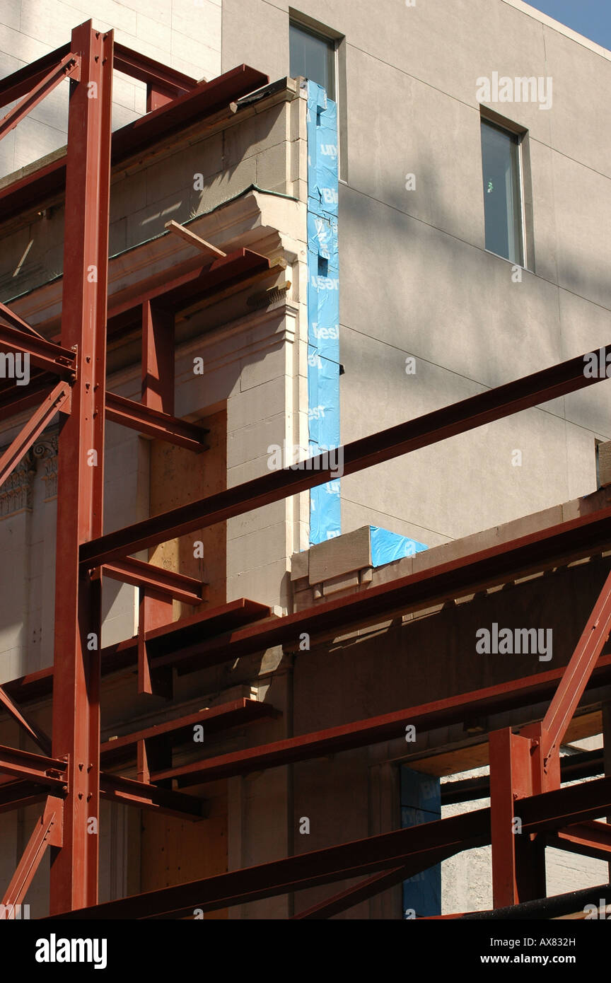 A series of red girders help support a wall at a construction site ...