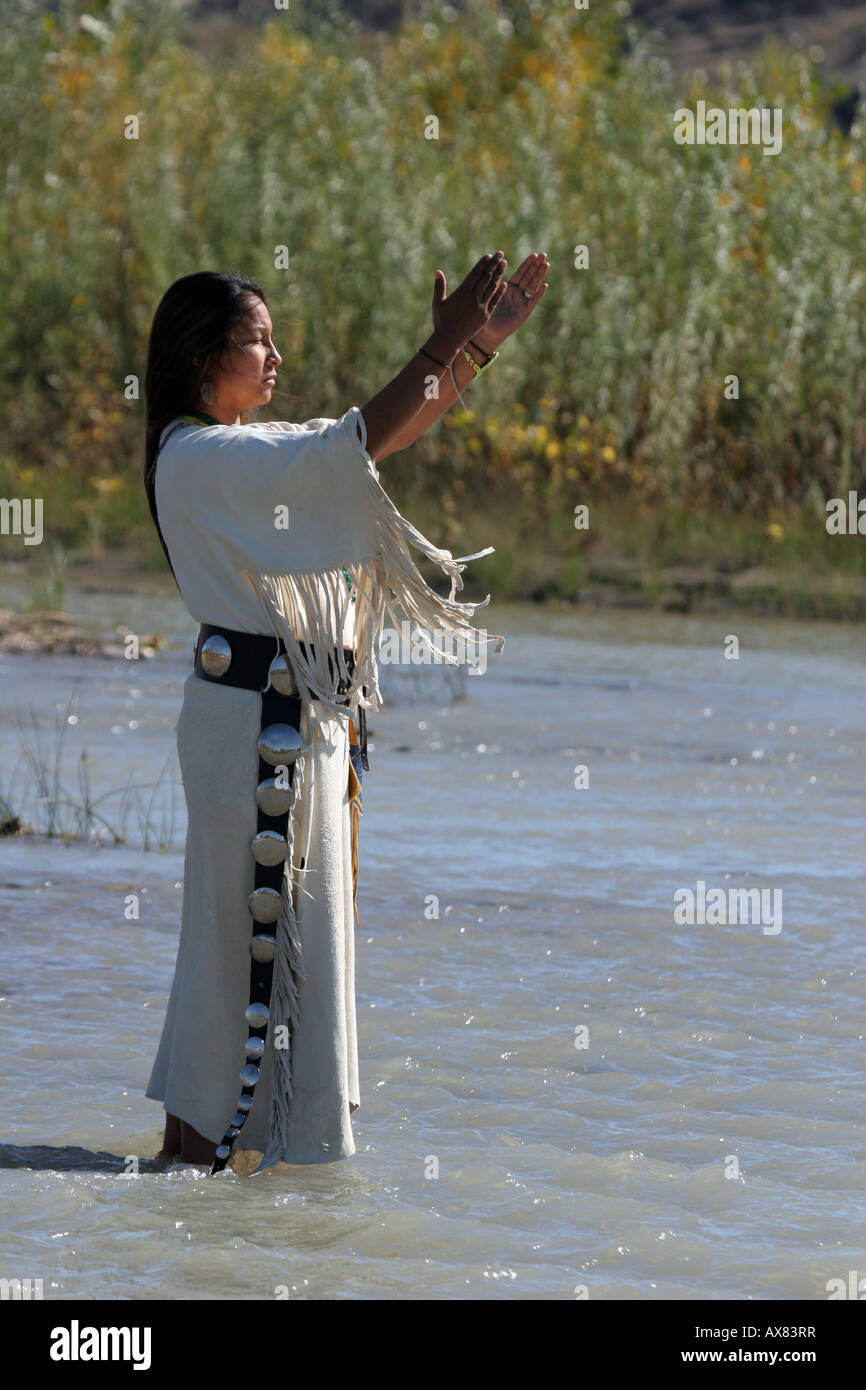 An Native American Indian women standing in the river holding her arms ...