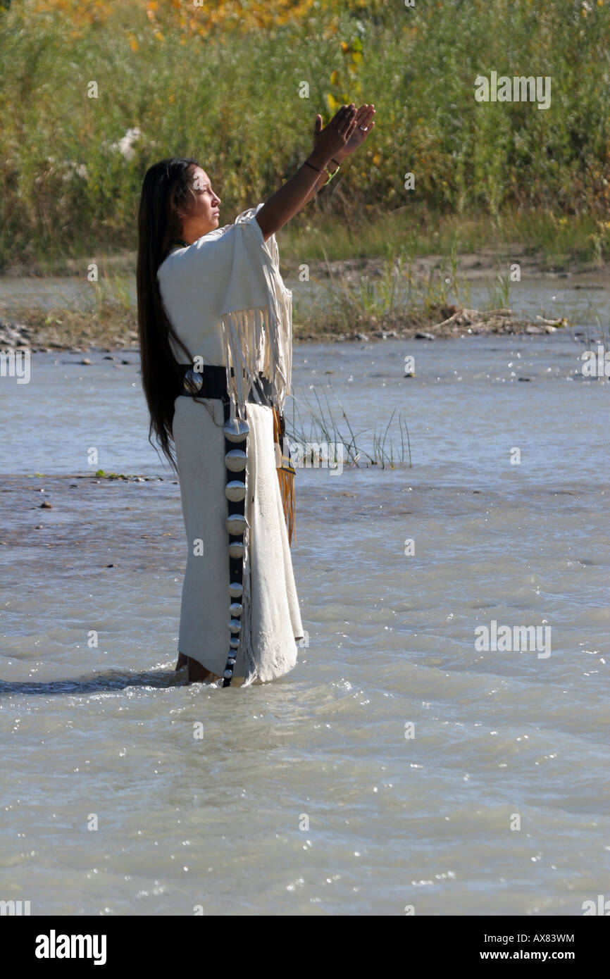 An Native American Indian women standing in the river holding her arms ...