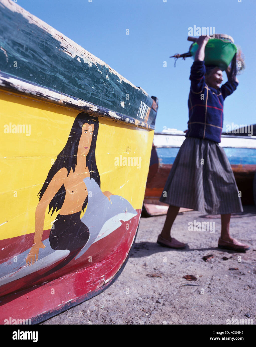 Local woman carrying fish in a basket, Fishing boat with painting of a ...