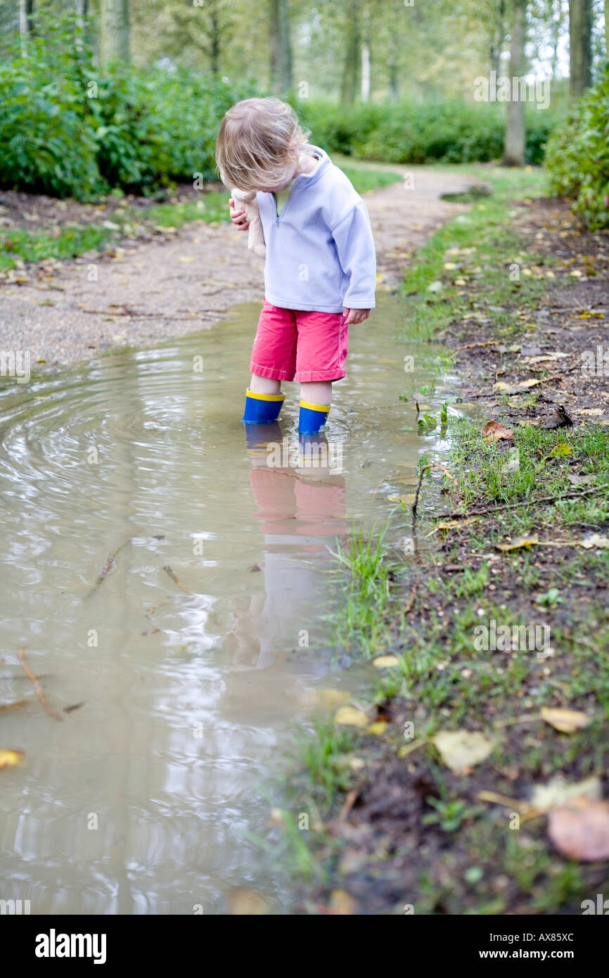 Girl standing in puddle Stock Photo - Alamy