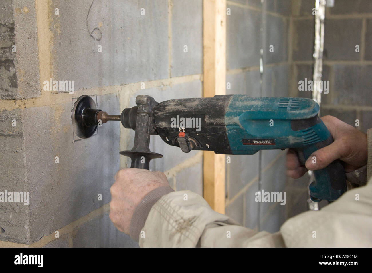a building drilling large 3 inch (76mm) holes in a wall using an SDS ...