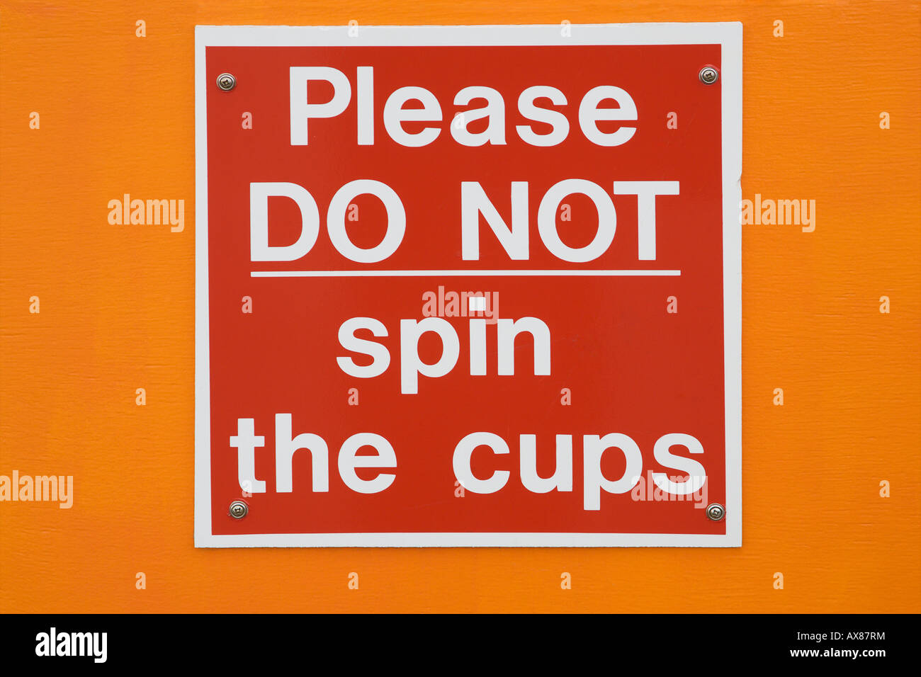 Orange hoarding with amusing red sign Do not spin the cups Stock Photo ...