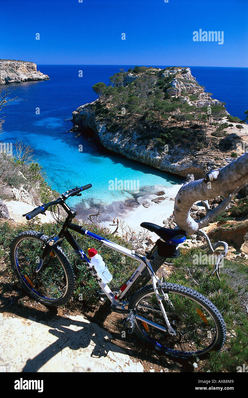 Mountain bike above beach in a bay under blue sky, Cala S´Amonia ...