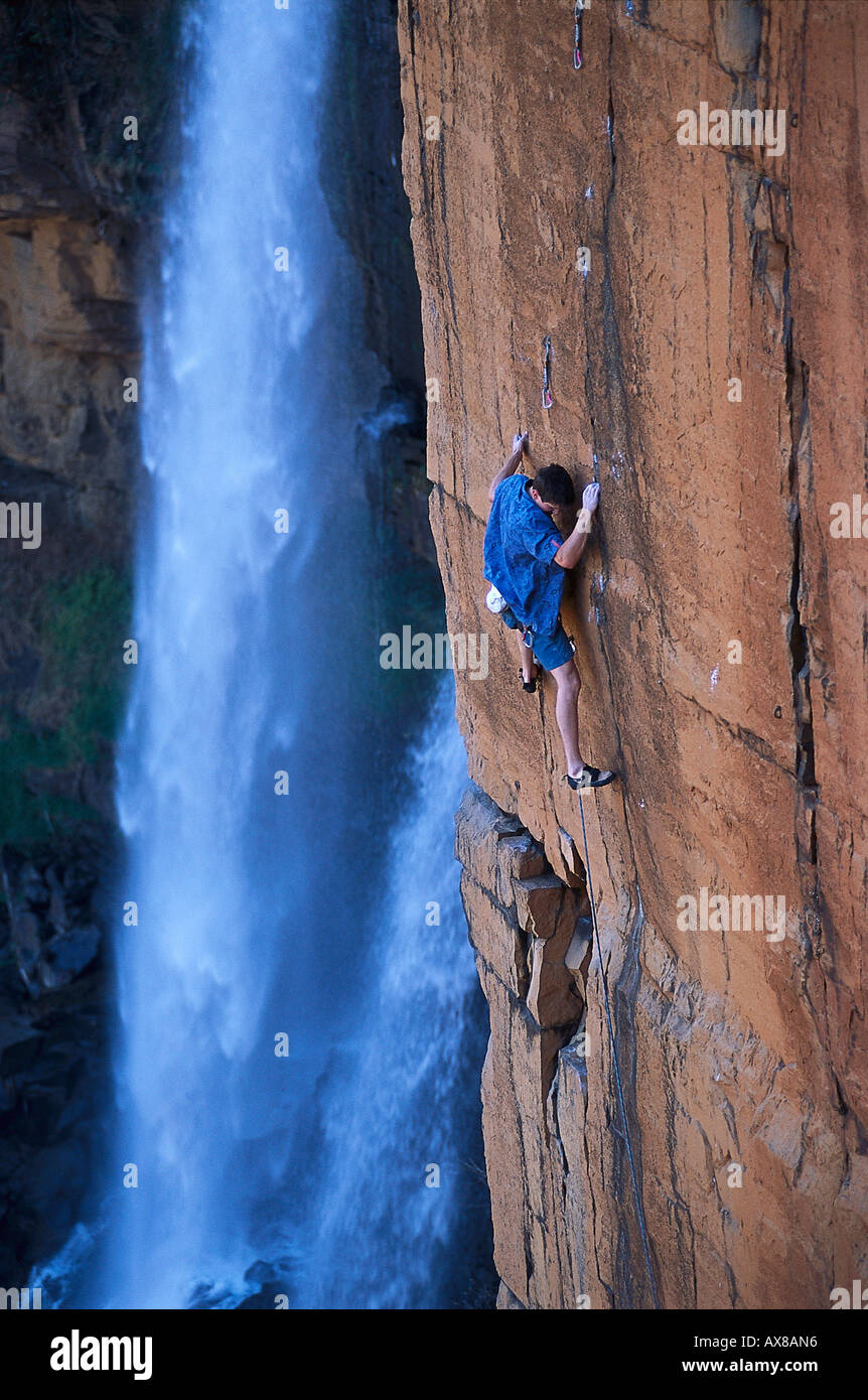 Man climbing a steep rock face near a waterfall, Waterval Boven, South ...