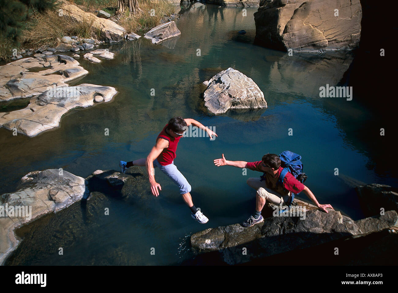 Two people crossing a river, Helping Hand, South Africa Stock Photo - Alamy
