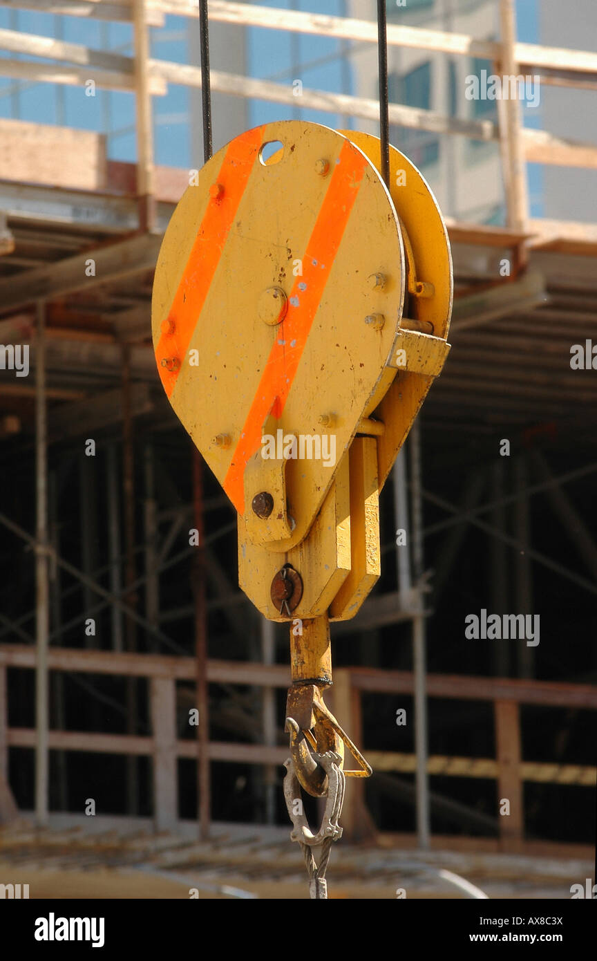A construction crane pulley with hazard markings at a construction site ...