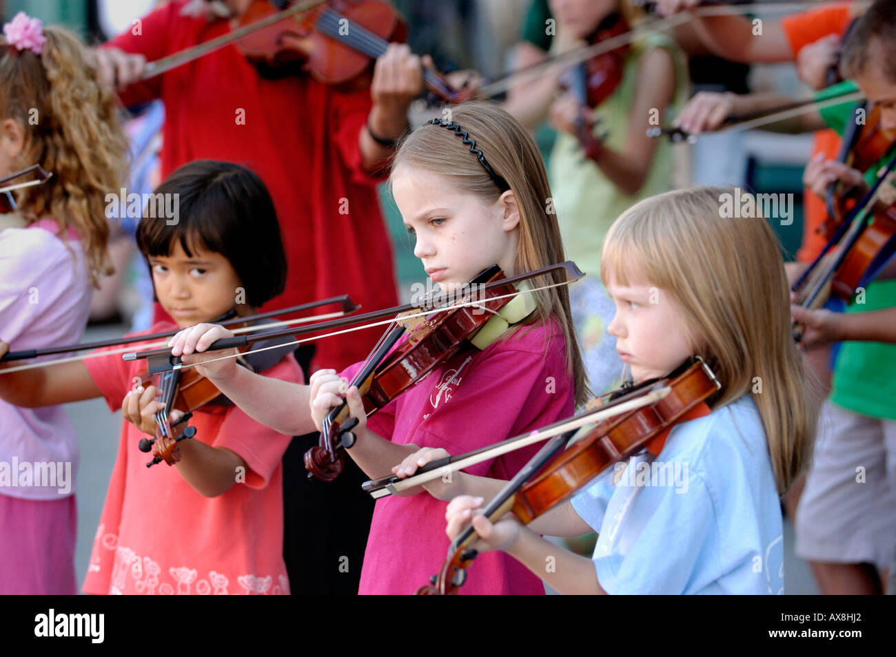 Violin strings group made up of children play a recital outside for the ...
