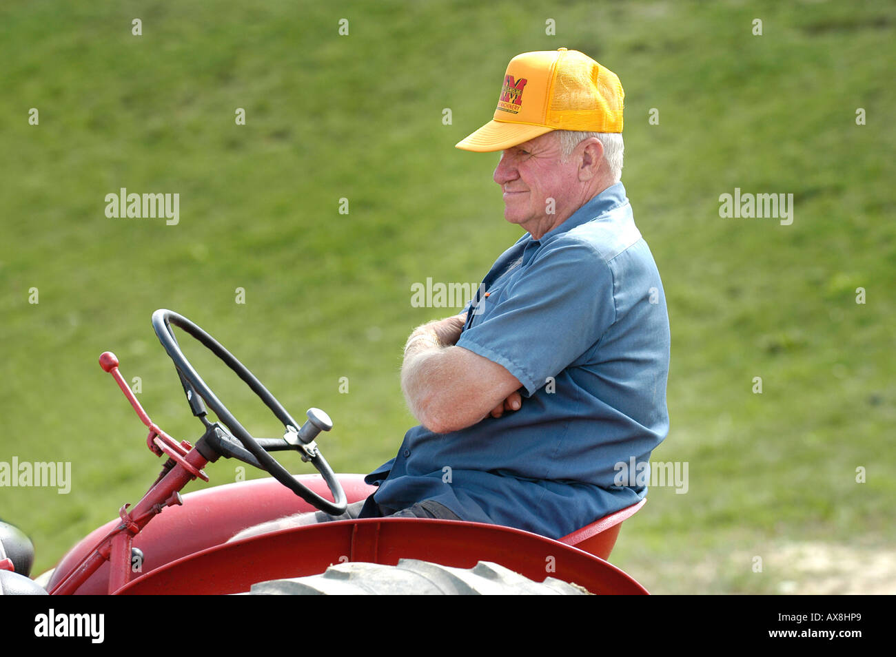Portrait of a male farmer sitting on a tractor Stock Photo - Alamy