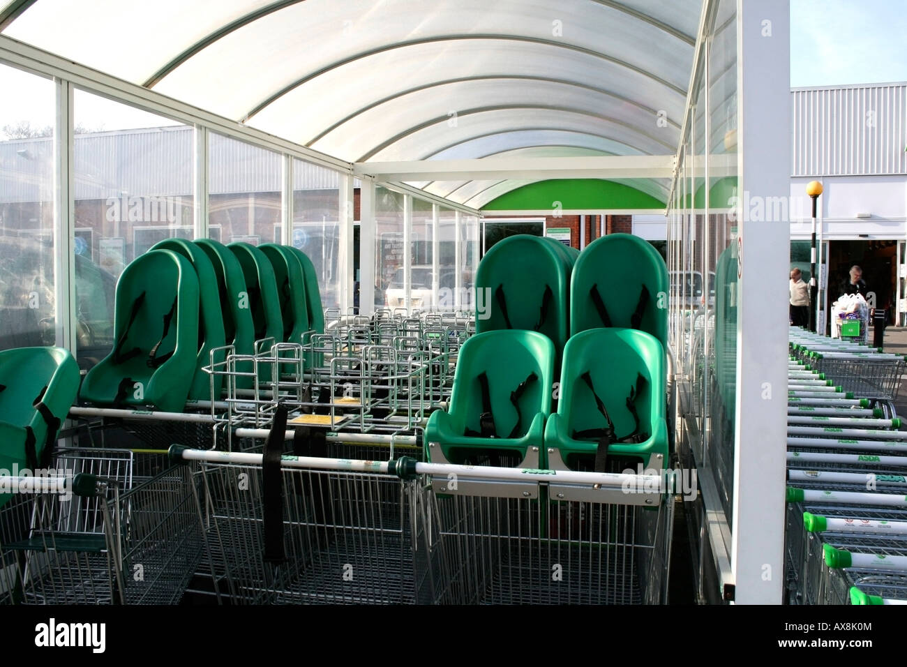 Shoppers crossing over trolley park in local supermaket Stock Photo - Alamy
