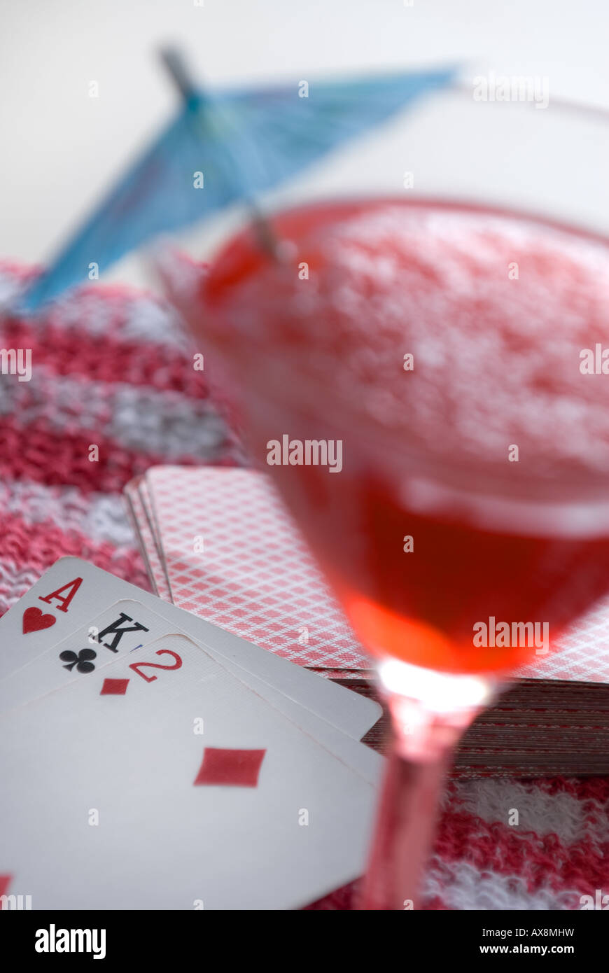 A hand of playing cards rest on a stack of playing cards behind a ...