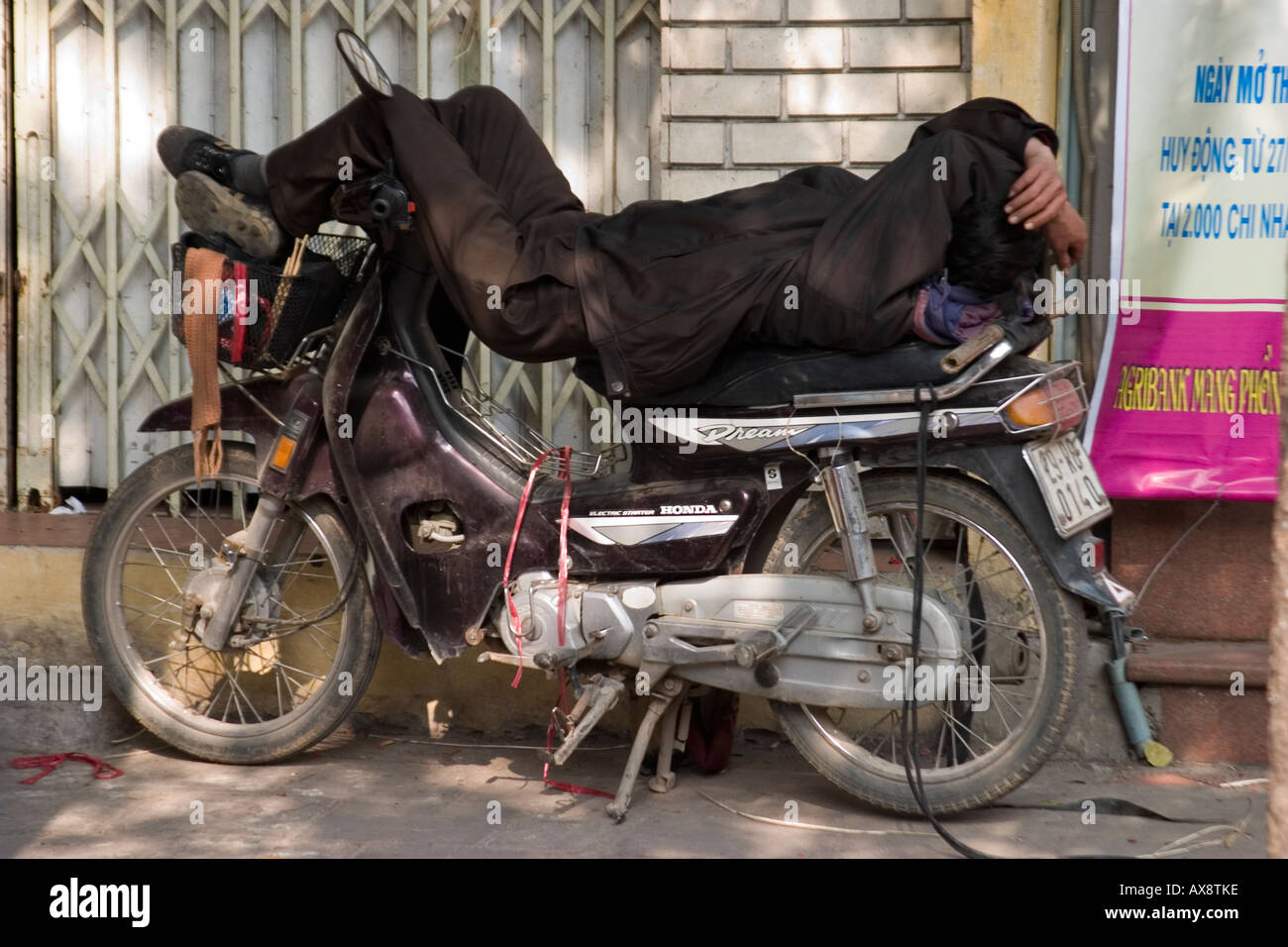 Mann sleeping on his motorbike - Hanoi Stock Photo - Alamy