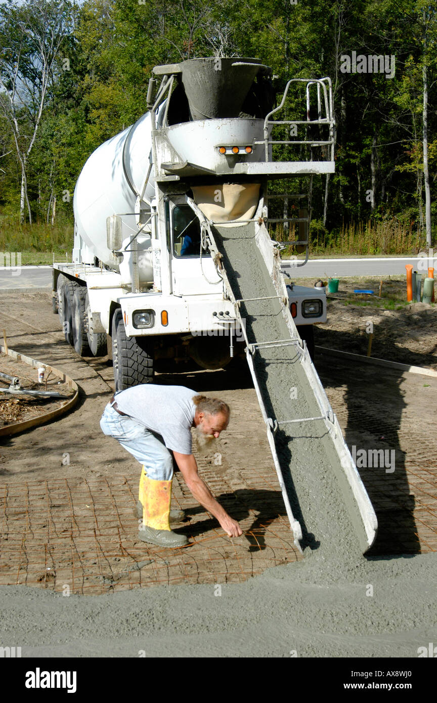 Cement Mason workers pour and finish a concrete driveway in a new home ...