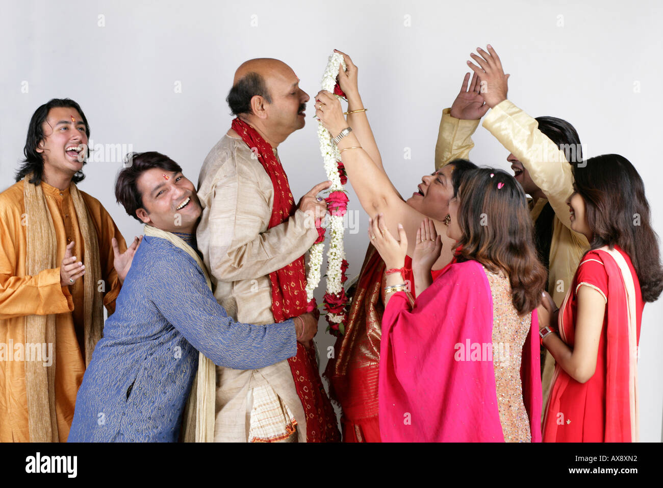 Senior couple getting married with their relatives standing aroung them ...