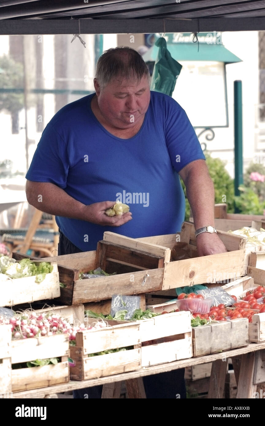 French outdoor market stall with man sorting through vegetables Stock ...