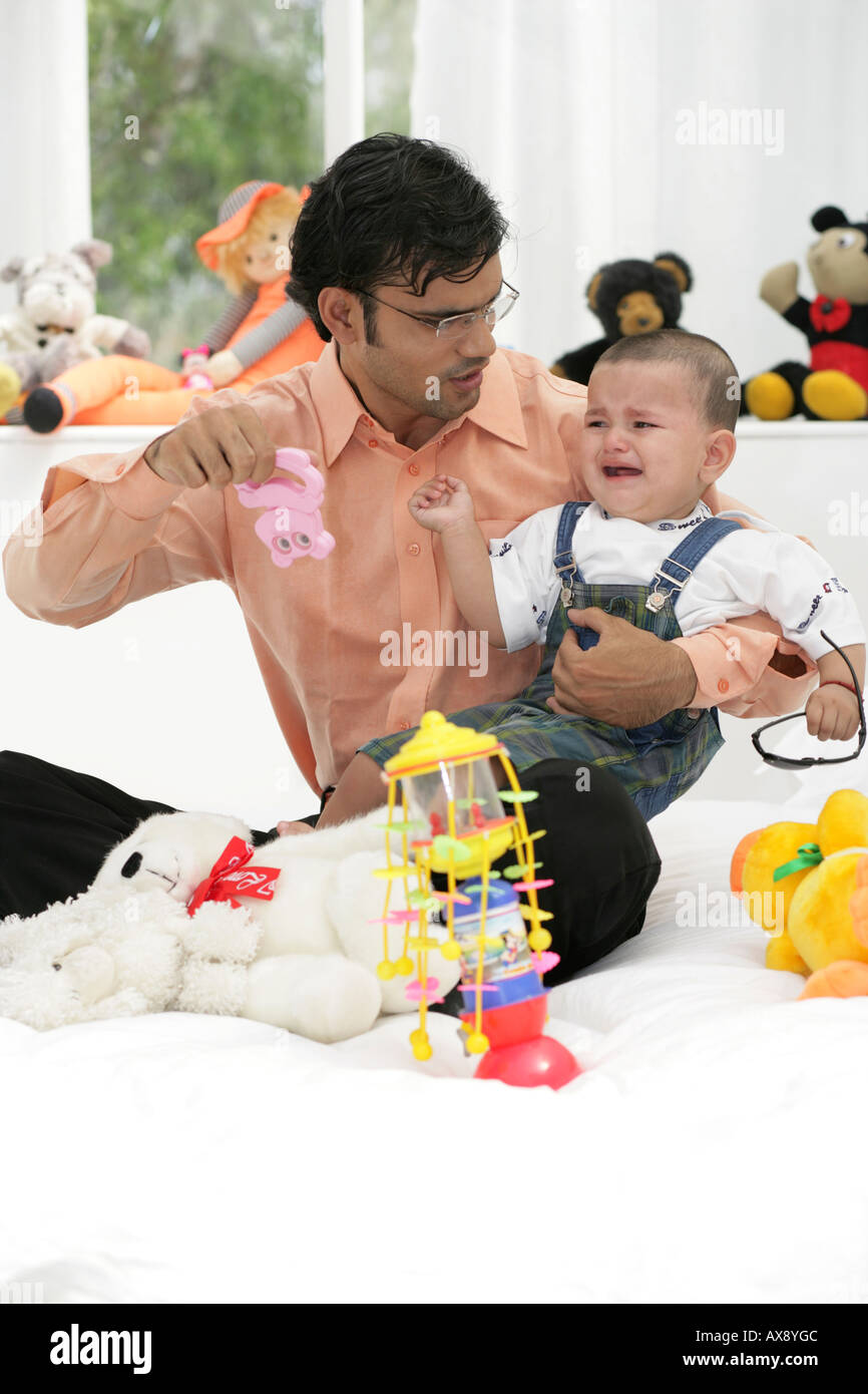 Father pacifying a crying baby son Stock Photo - Alamy