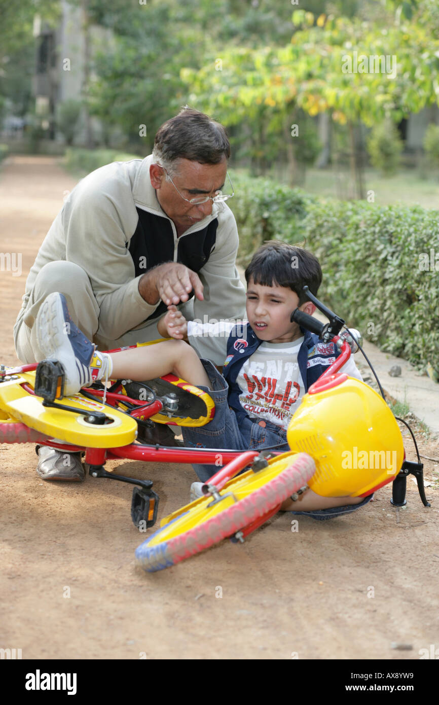 Boy falls from a bicycle and his grandfather supporting him Stock Photo ...