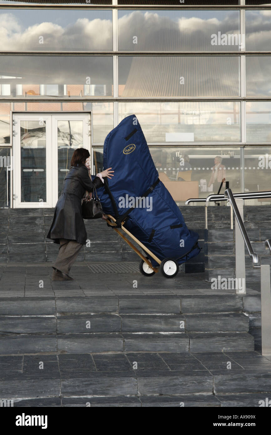 Woman pushes a harp outside Welsh Assembly Government Senedd Building ...