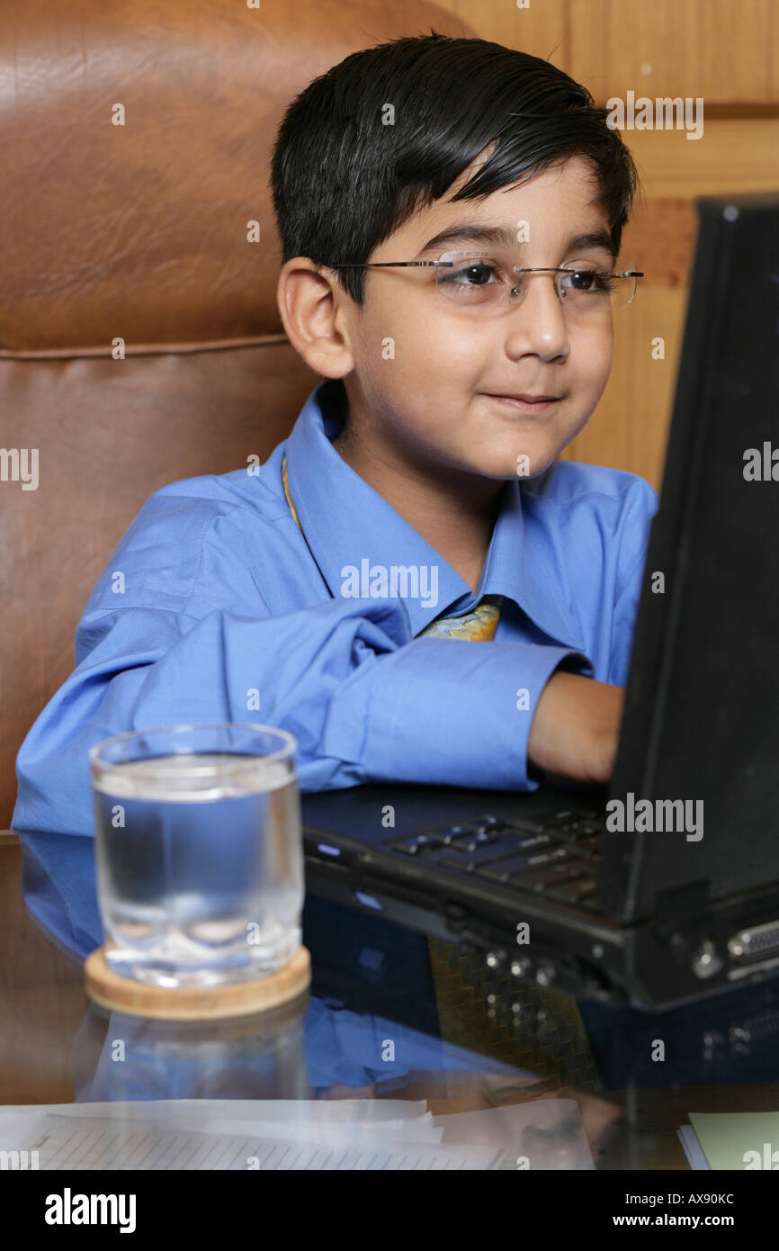 Boy imitating like a businessman and working on laptop Stock Photo - Alamy