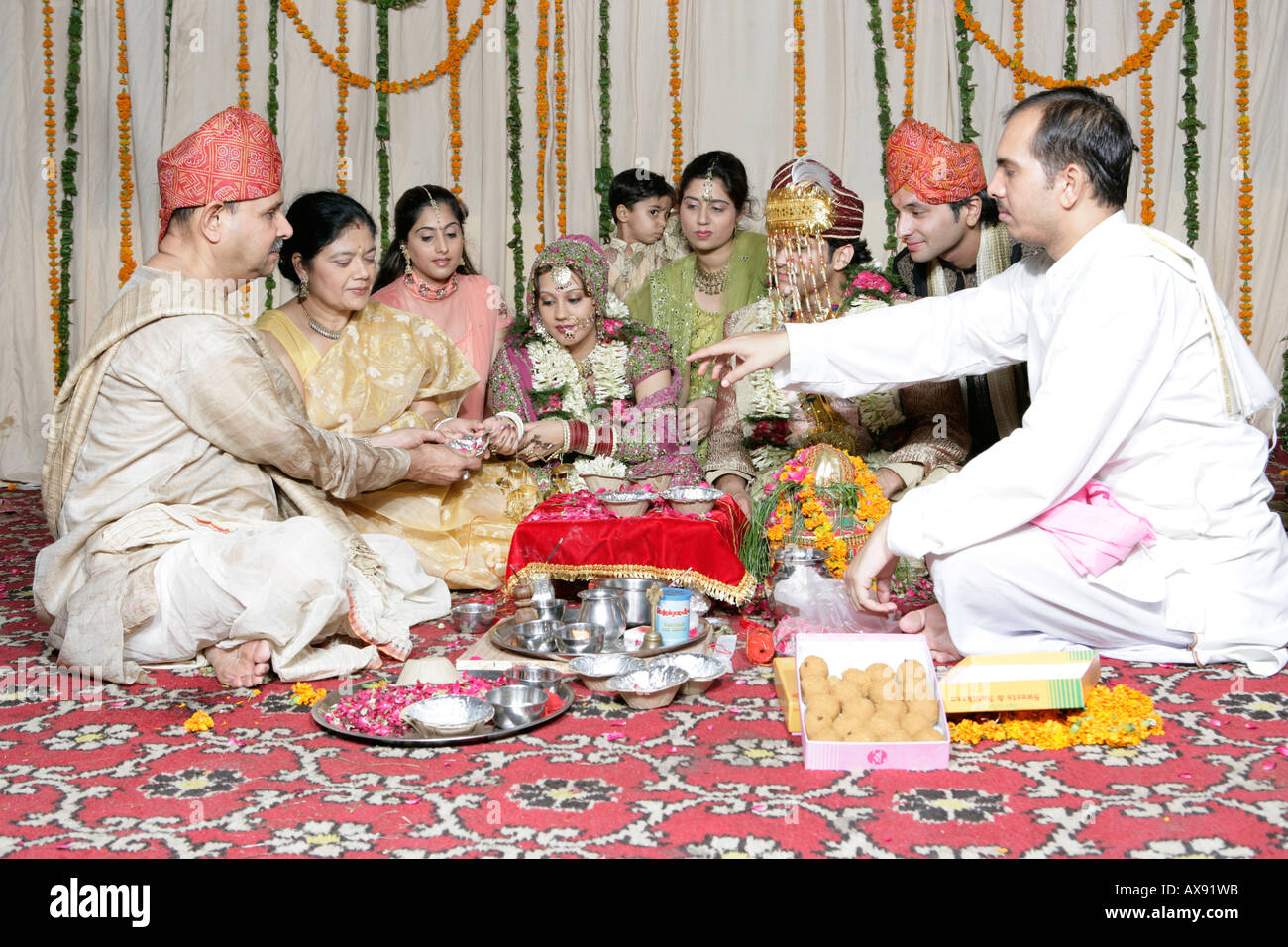 Bride groom getting married with their relative and a priest sitting ...