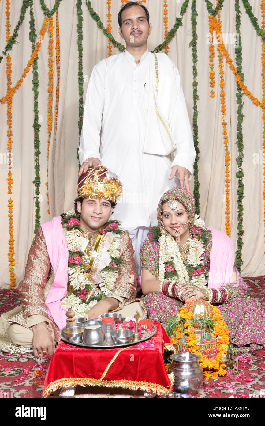 Portrait of a Bride and a groom getting married with priest blessing ...
