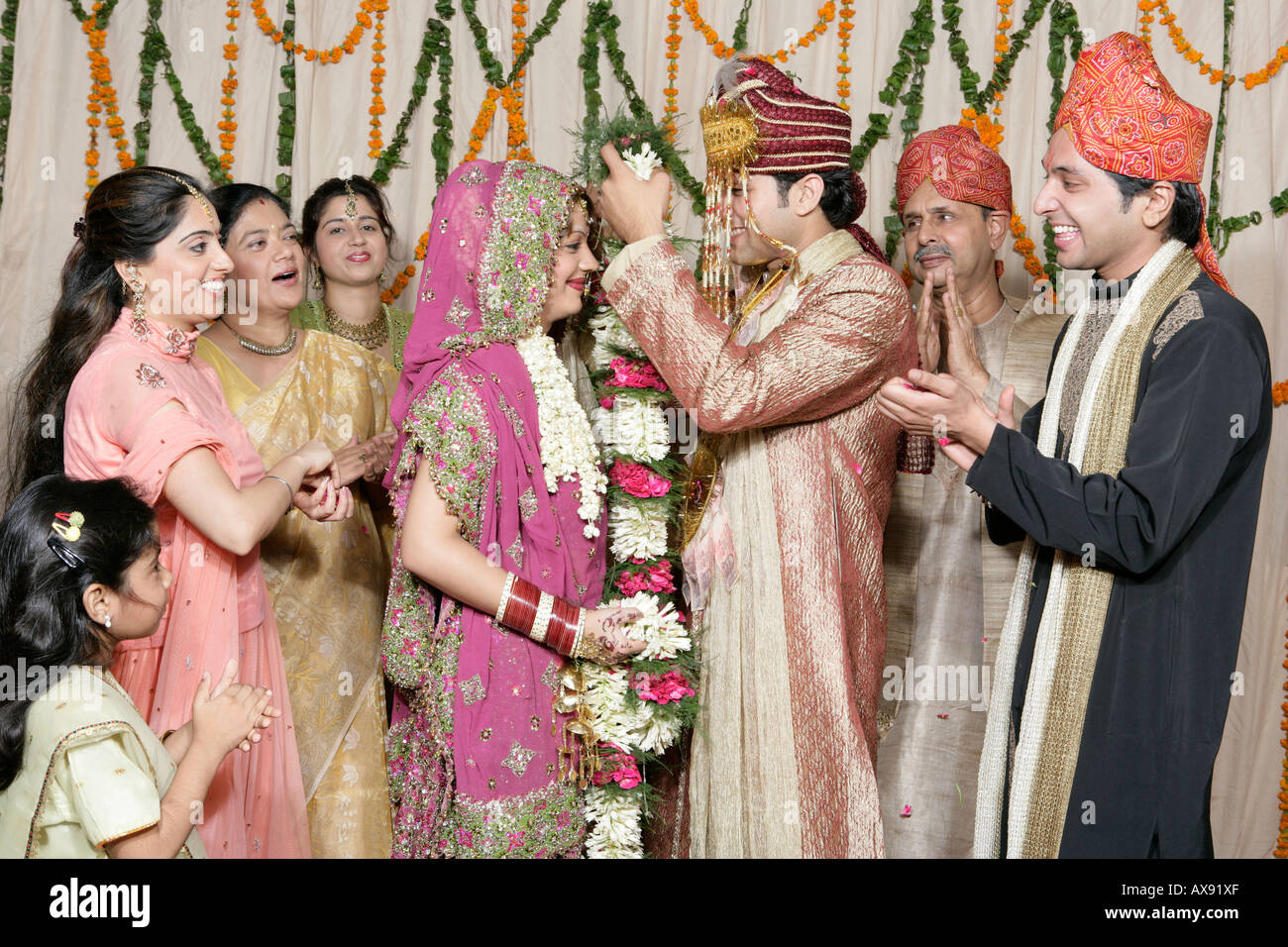 Bride and groom getting married with their relatives cheering around ...