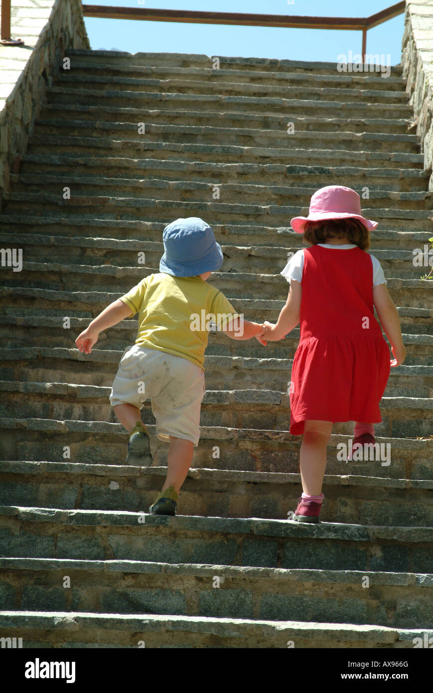 girl giving hand to boy going up steps Stock Photo - Alamy