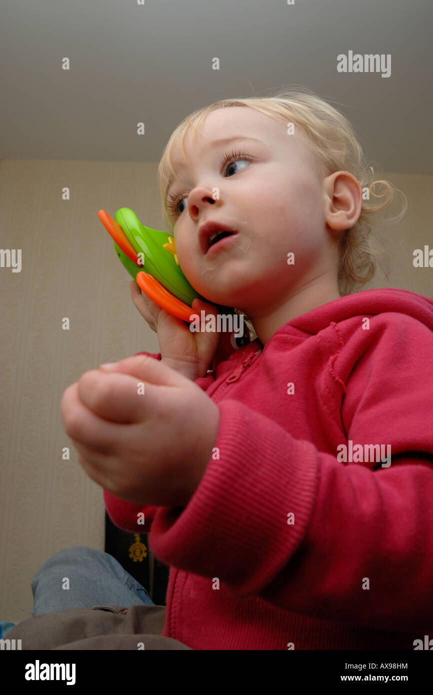 Toddler using a toy mobile phone Stock Photo - Alamy