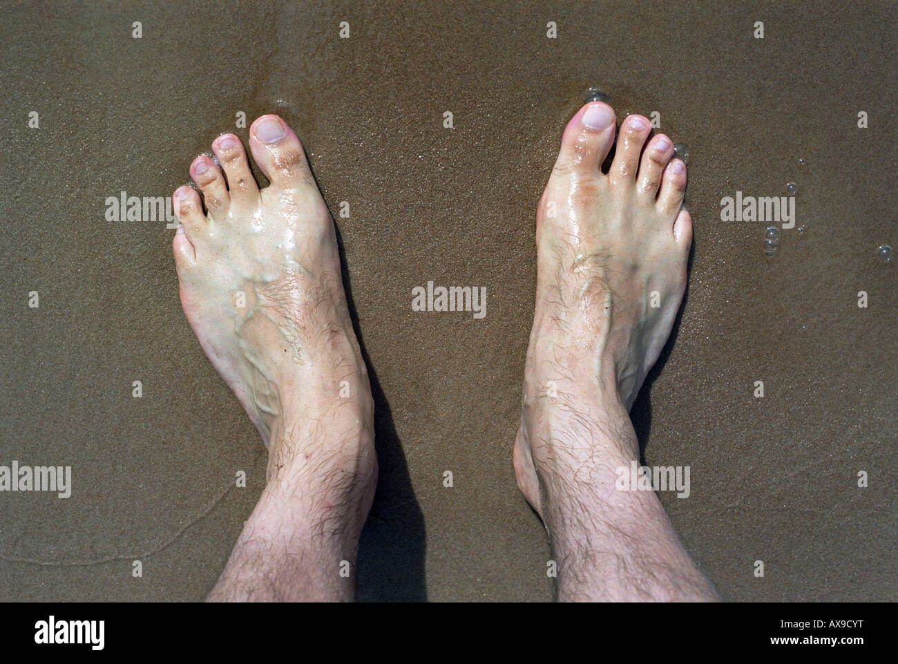 Male feet on a beach Stock Photo - Alamy