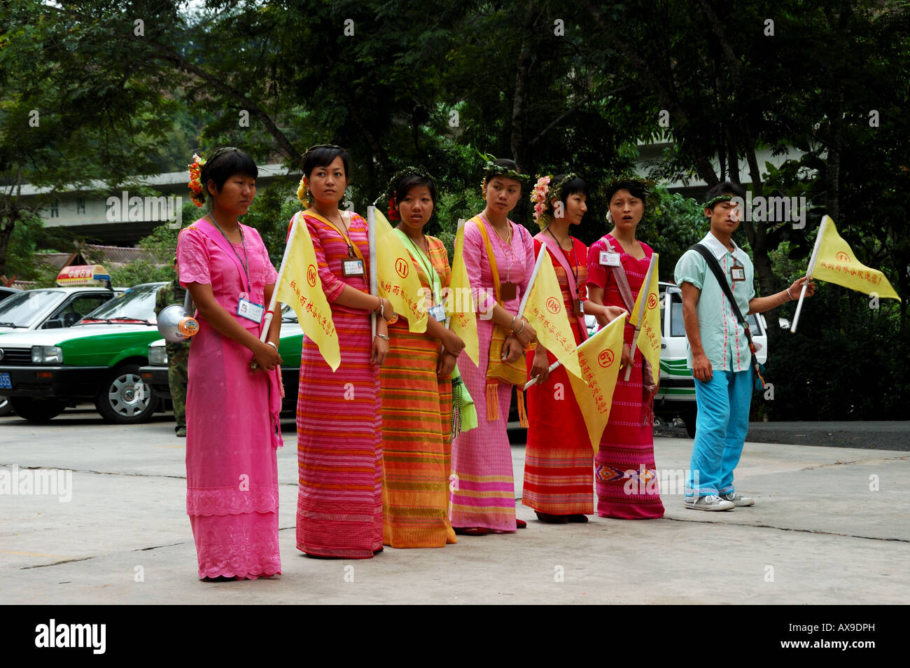 Girls working as tour guides line up in front of a tourist attraction ...